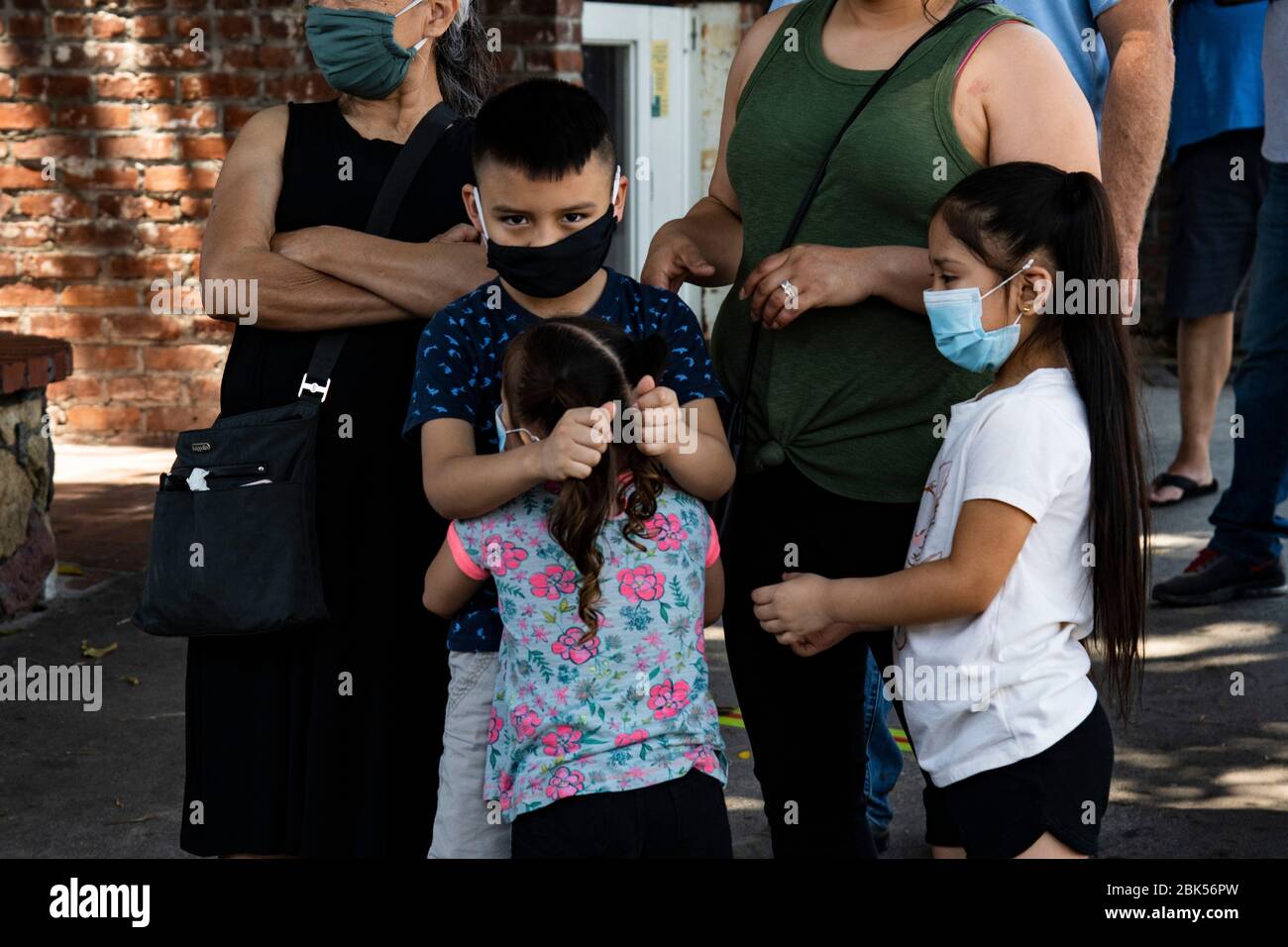Family together wait in a line outside grocery store Stock Photo - Alamy