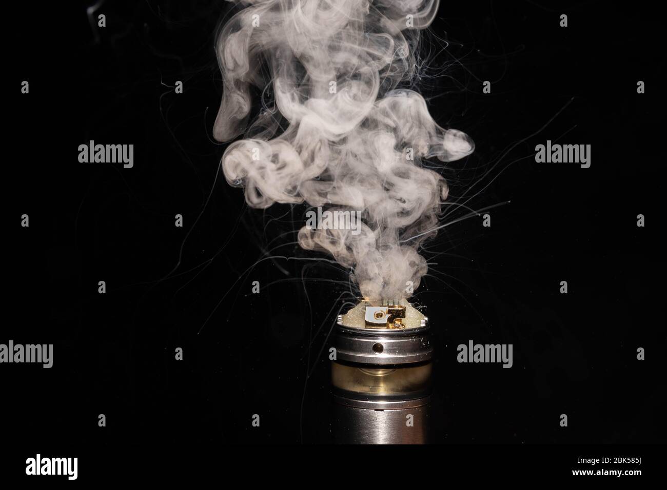 lit electronic cigarette releasing smoke with black background Stock ...