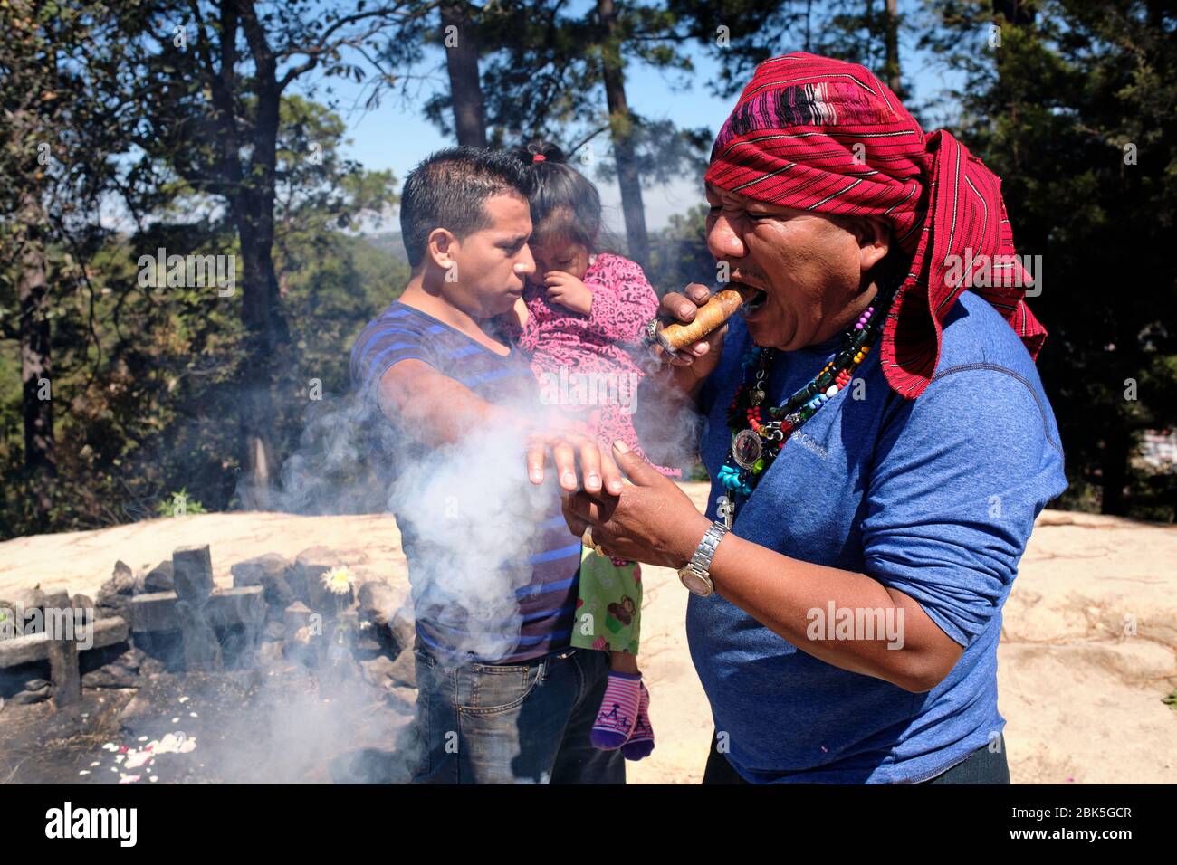 Shaman performing a Mayan healing ceremony for a family on the top of ...