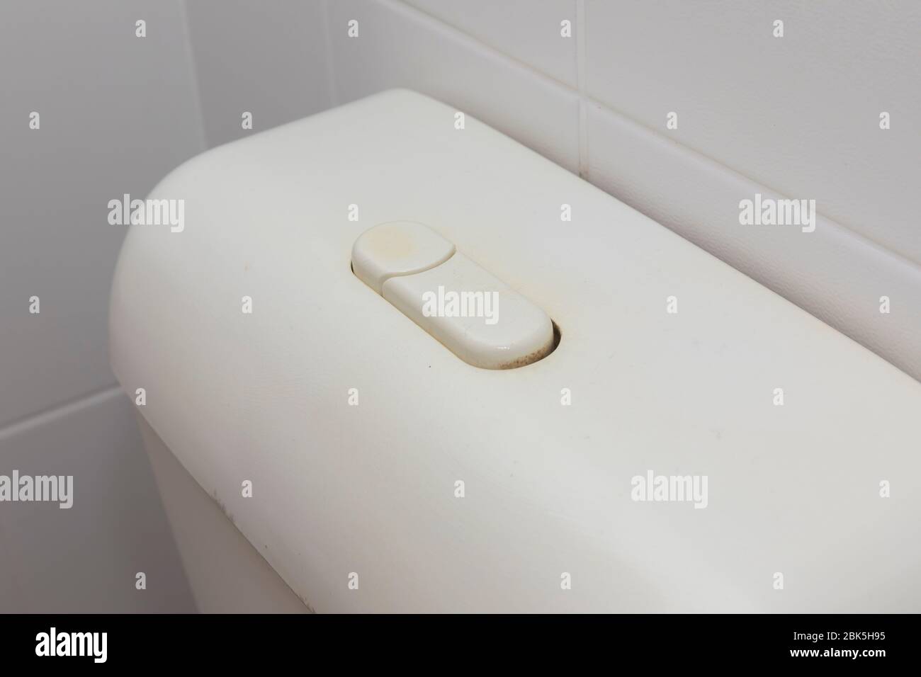 The flush buttons on an old and dirty toilet cistern Stock Photo - Alamy