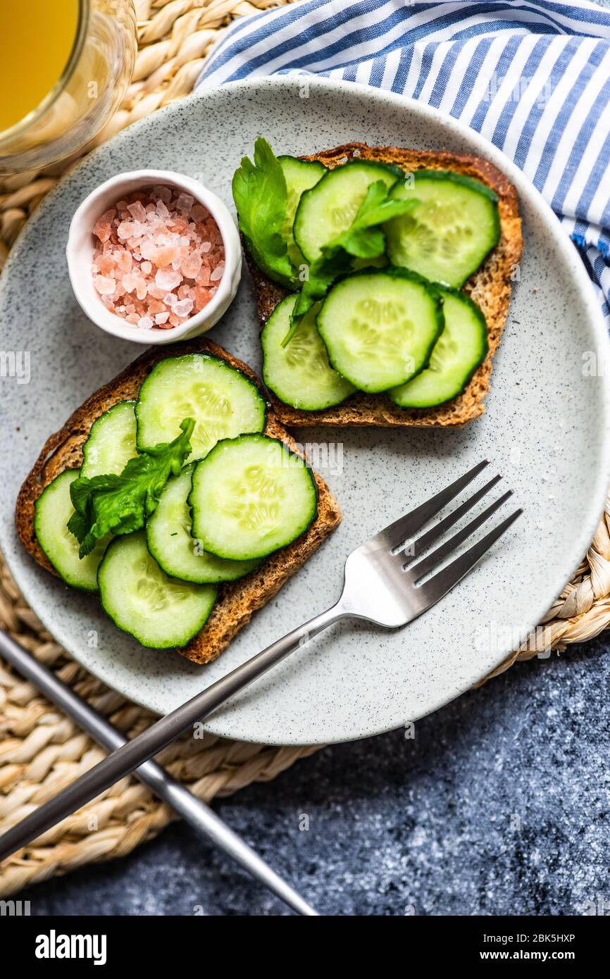 Healthy lunch concept with toasts with organic cucumber, rocket herb ...