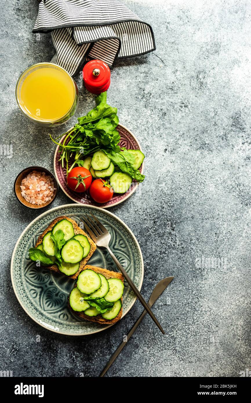 Healthy lunch concept with toasts with organic cucumber, rocket herb ...