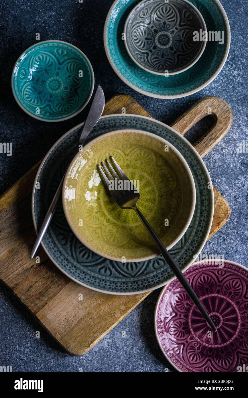 Rustic table setting with ceramic plates and cutlery set on stone ...