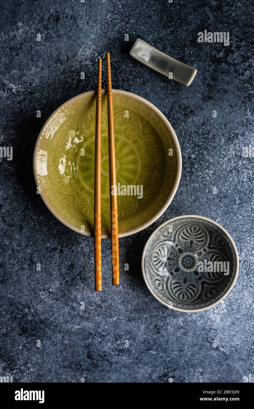 Asian table setting with wooden chopsticks and ceramic bowls on stone ...