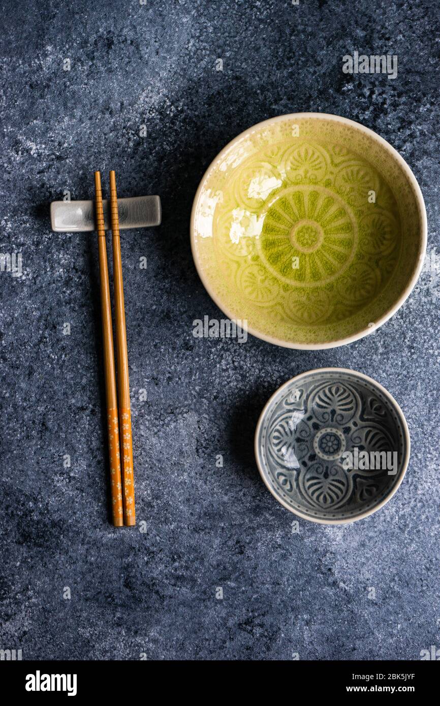 Asian table setting with wooden chopsticks and ceramic bowls on stone ...