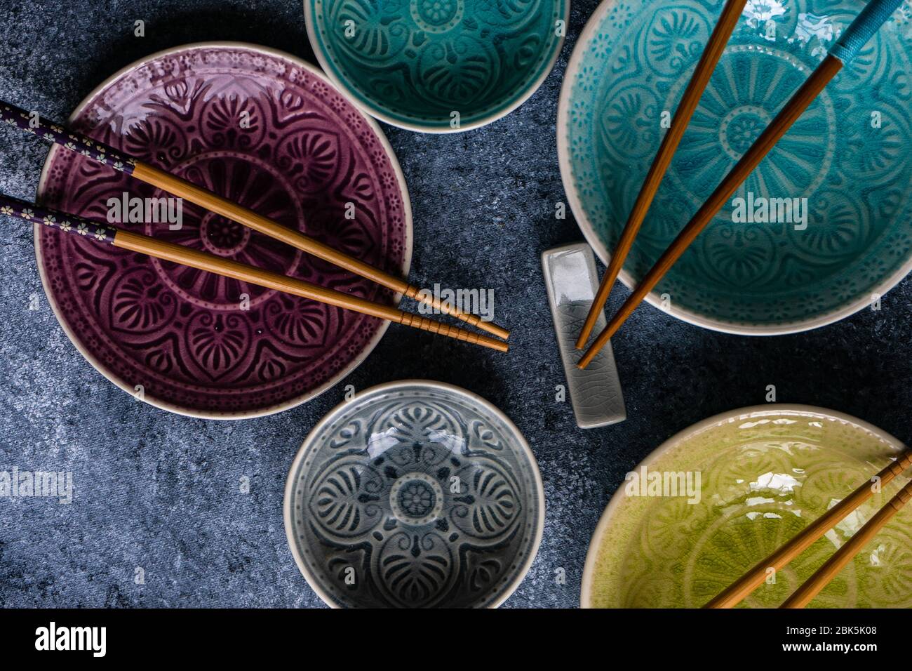 Asian table setting with wooden chopsticks and ceramic bowls on stone ...