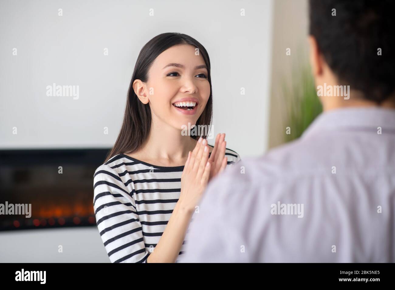 Happy young woman clapping her hands in front of her husband Stock ...