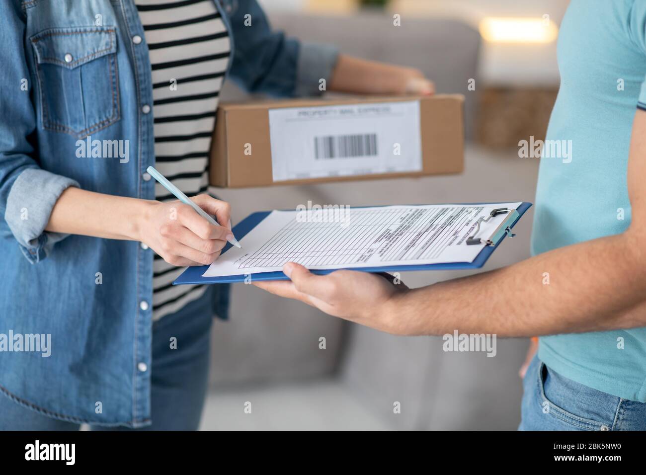 Female hands holding parcel and signing delivery documents Stock Photo ...