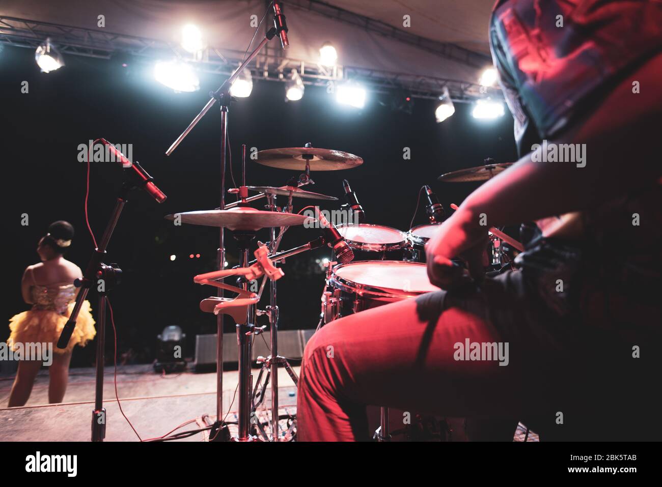 Rock band performs live at rock show on stage. Guitarist, bass guitar ...