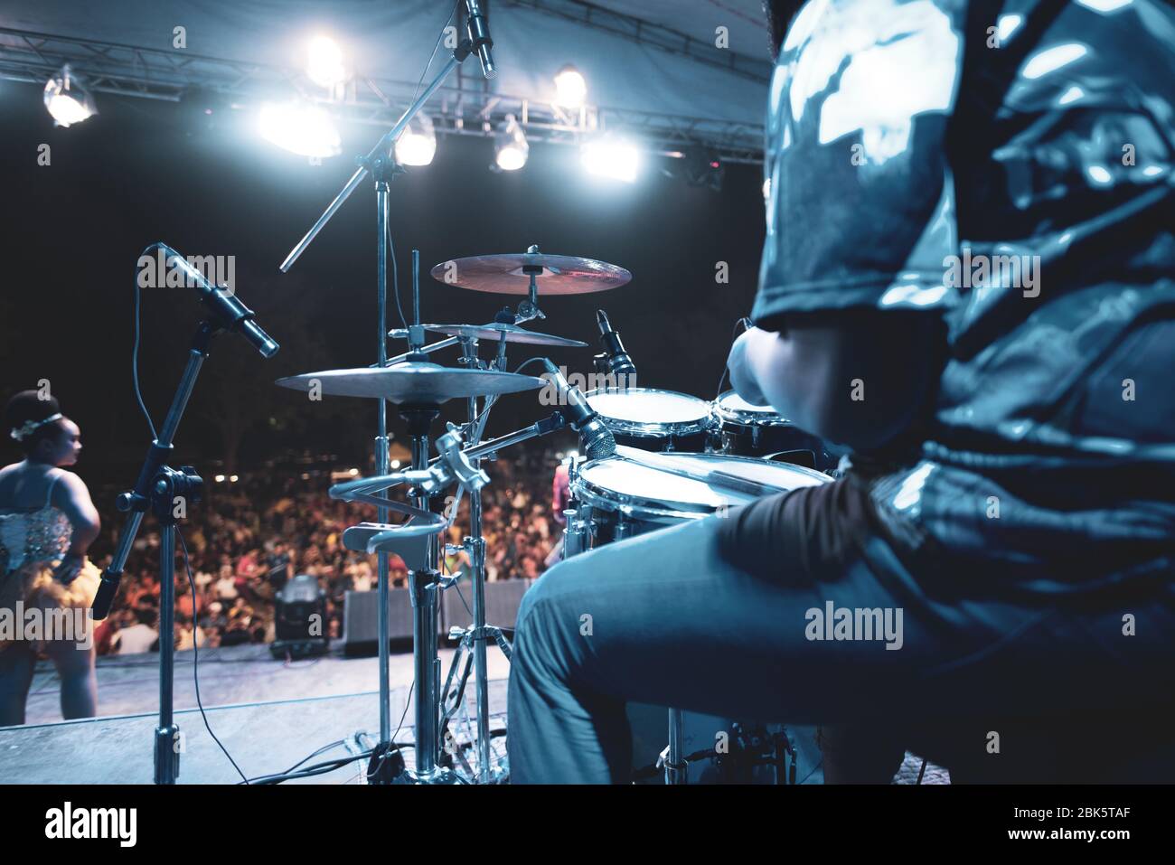 Rock band performs live at rock show on stage. Guitarist, bass guitar ...