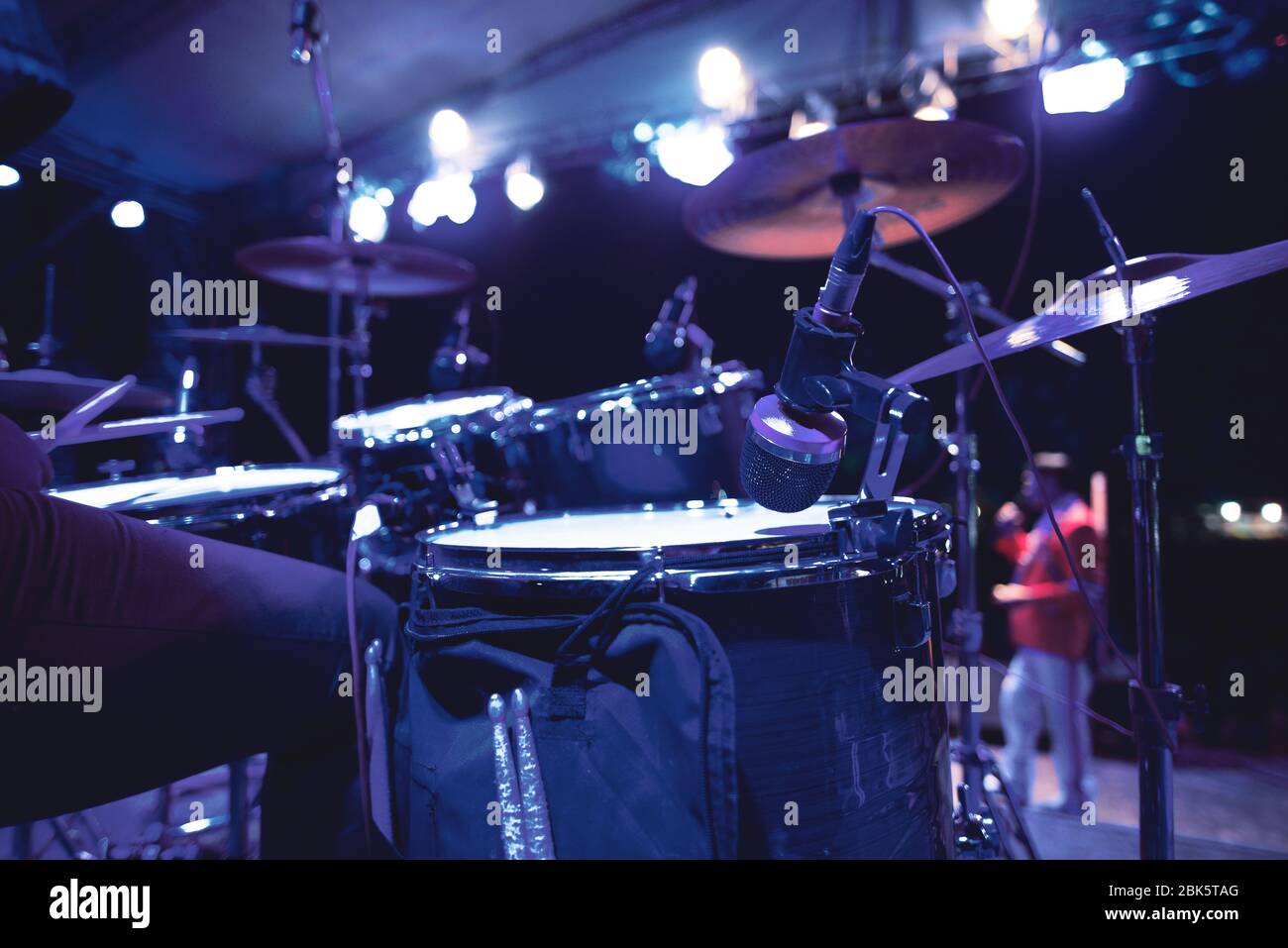 Rock band performs live at rock show on stage. Guitarist, bass guitar ...