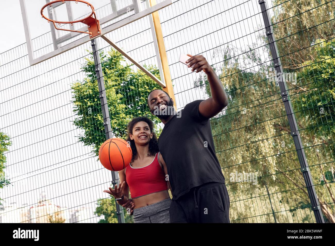 Outdoors Activity. African couple standing on basketball court ...