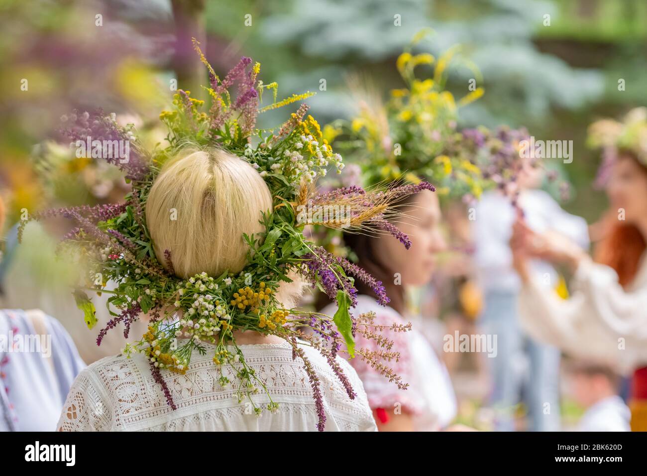 Unidentified women in traditional dresses with summer solstice wreaths ...