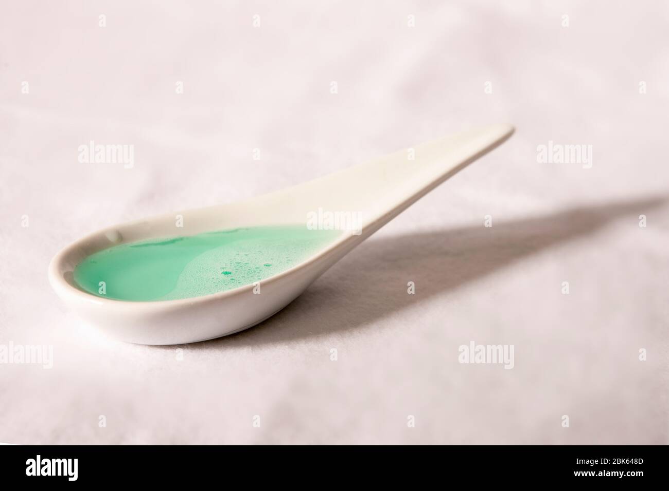 green liquid on ceramic spoon with pipette Stock Photo - Alamy