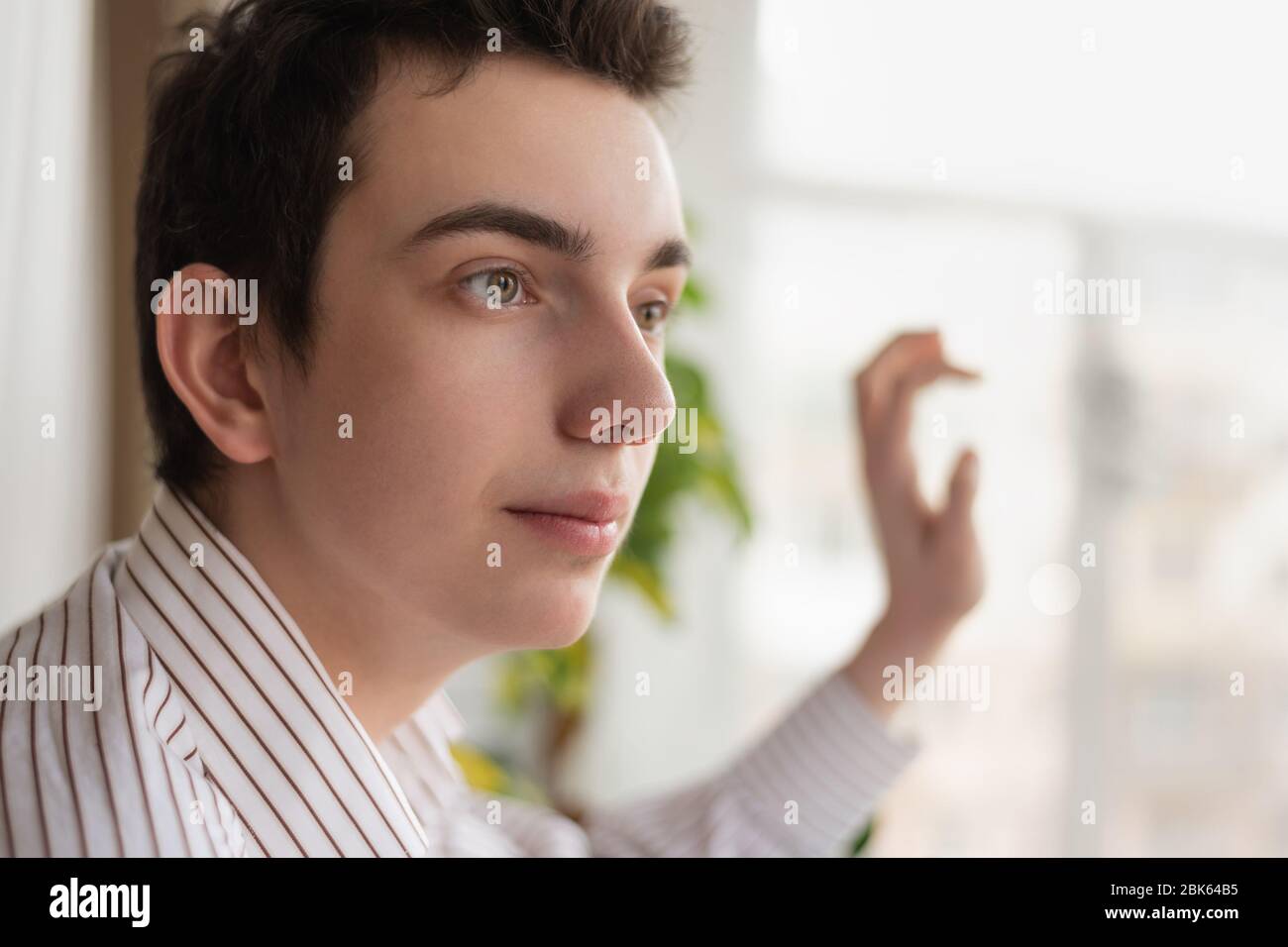 Pensive guy looking out window at home Stock Photo - Alamy