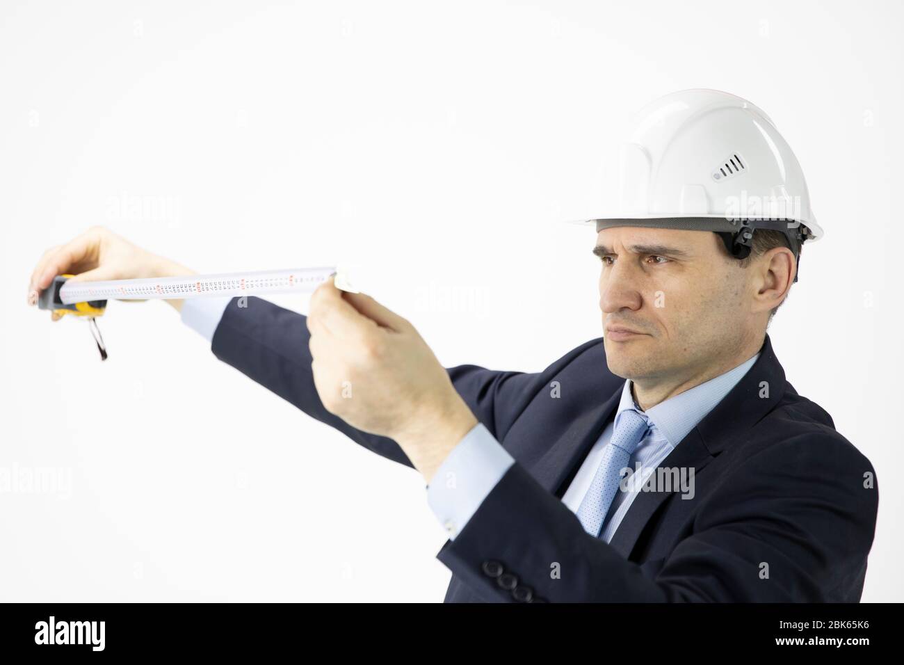 Close up construction engineer in safety helmet looking on measuring ...