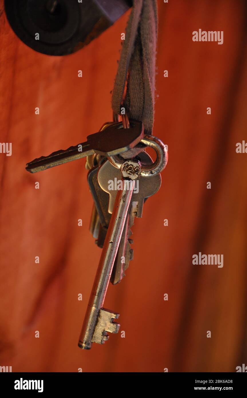 Retro keys in bunch hanging on dirty braid with wooden background ...