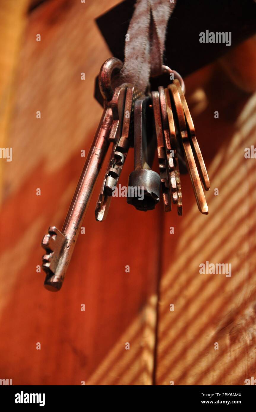 Bunch of retro keys hanging on dirty braid with wooden background ...