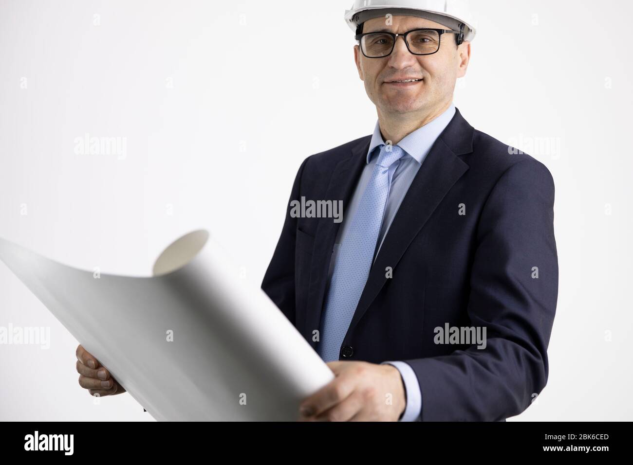 Smiling civil engineer working with documents isolated on white ...