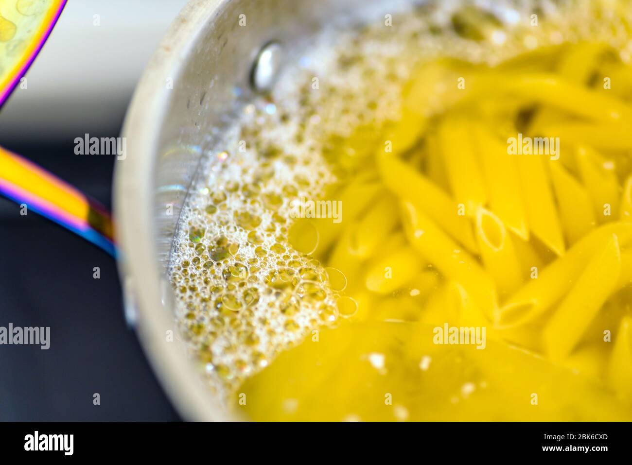 italian penne rigate macaroni pasta cooking inside large pan caserole ...