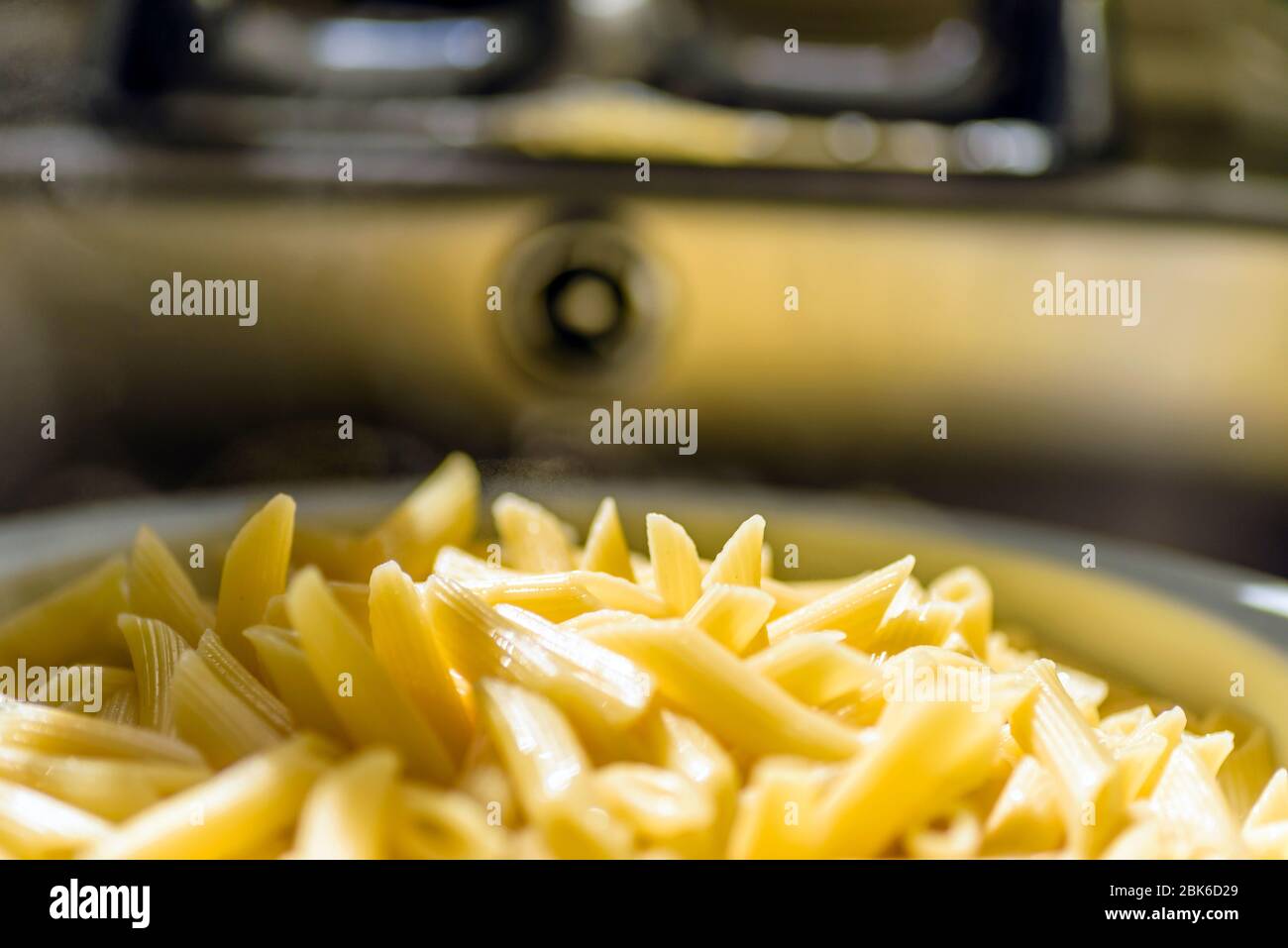 cooked italian penne rigate macaroni pasta draining Stock Photo - Alamy