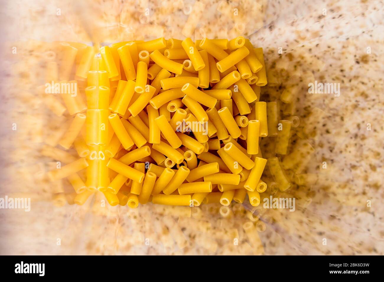raw italian macaroni pasta inside clear storage container Stock Photo ...