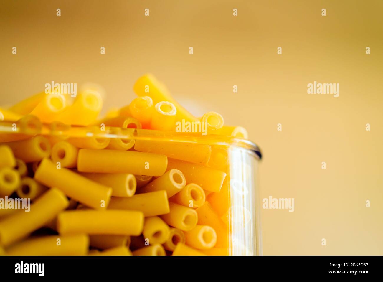 raw italian macaroni pasta inside clear storage container Stock Photo ...