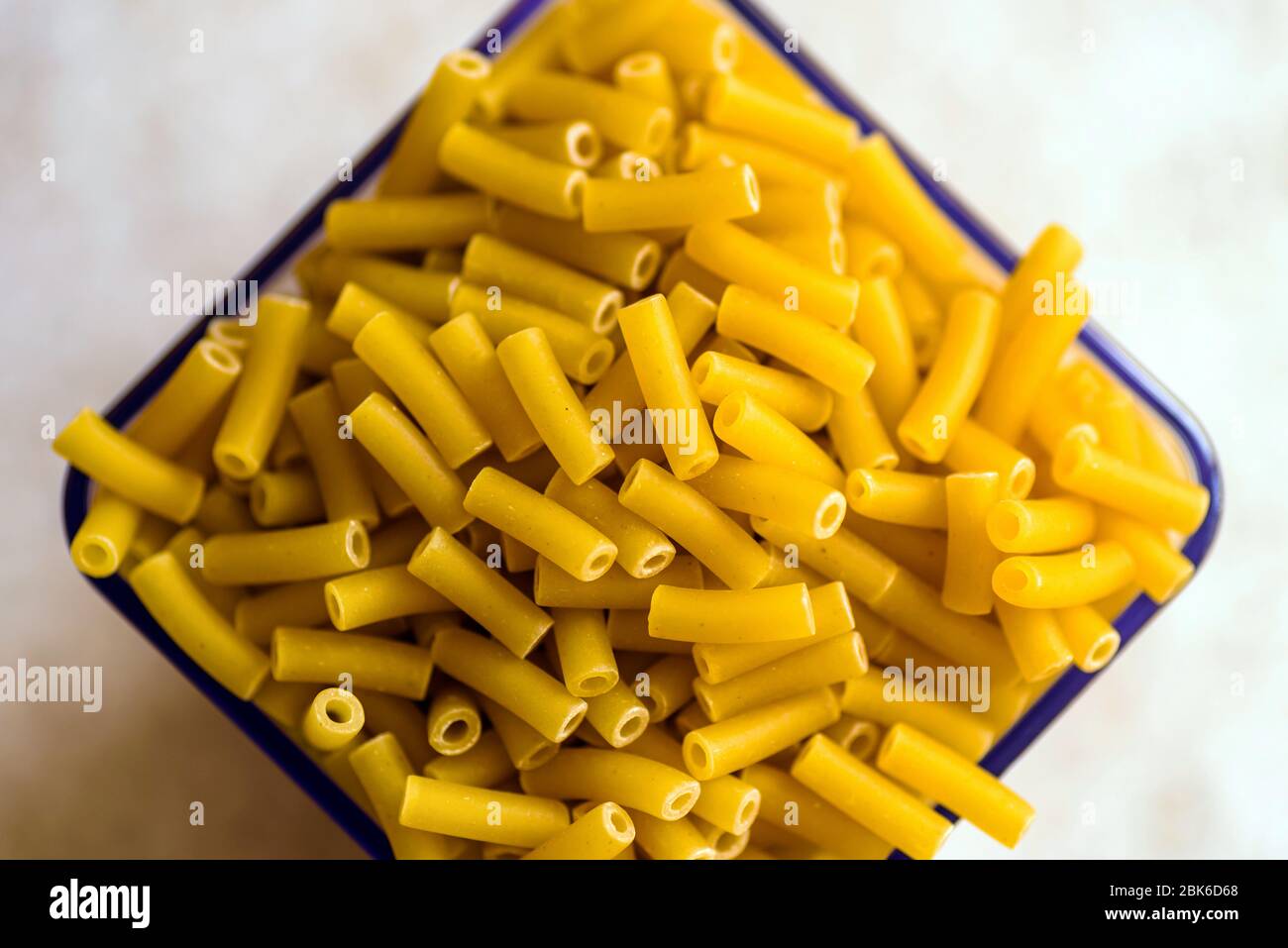 raw italian macaroni pasta inside clear storage container Stock Photo ...