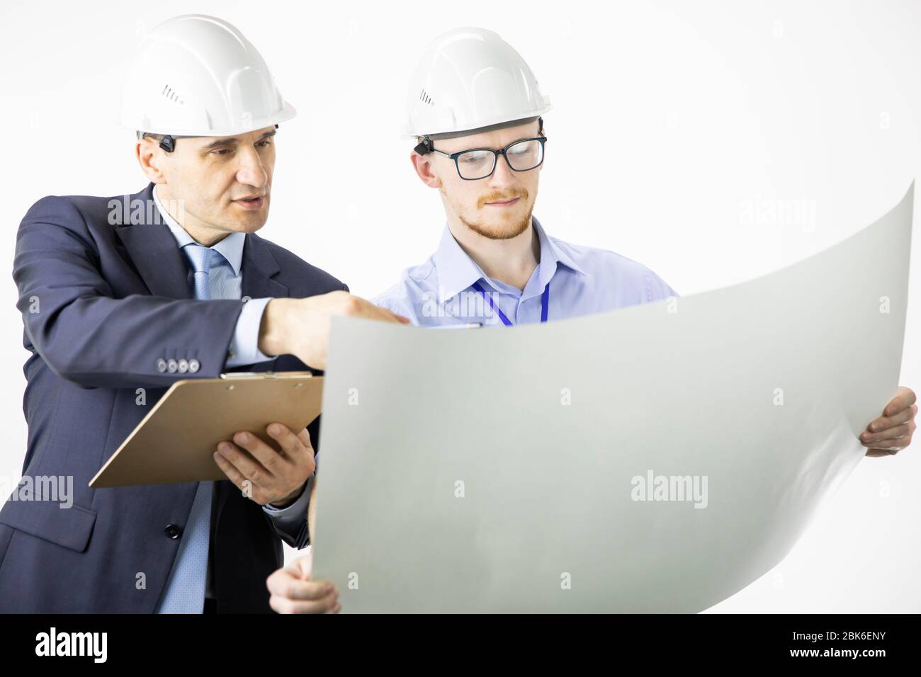 Architectural engineers work with blueprint documents reading ...