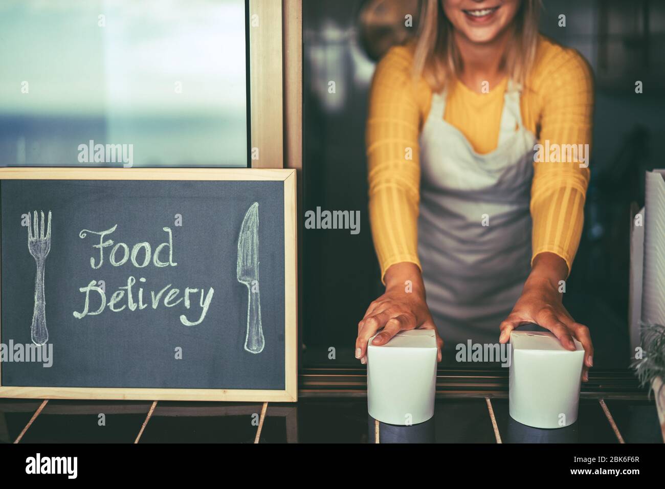 Young woman serving healthy take away food inside restaurant - Happy ...