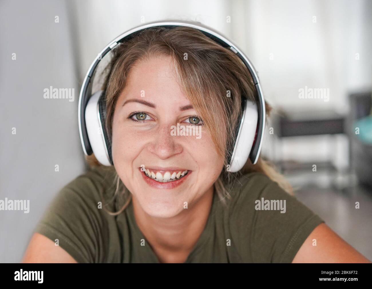 Young blond woman chatting online during isolation quarantine from home ...