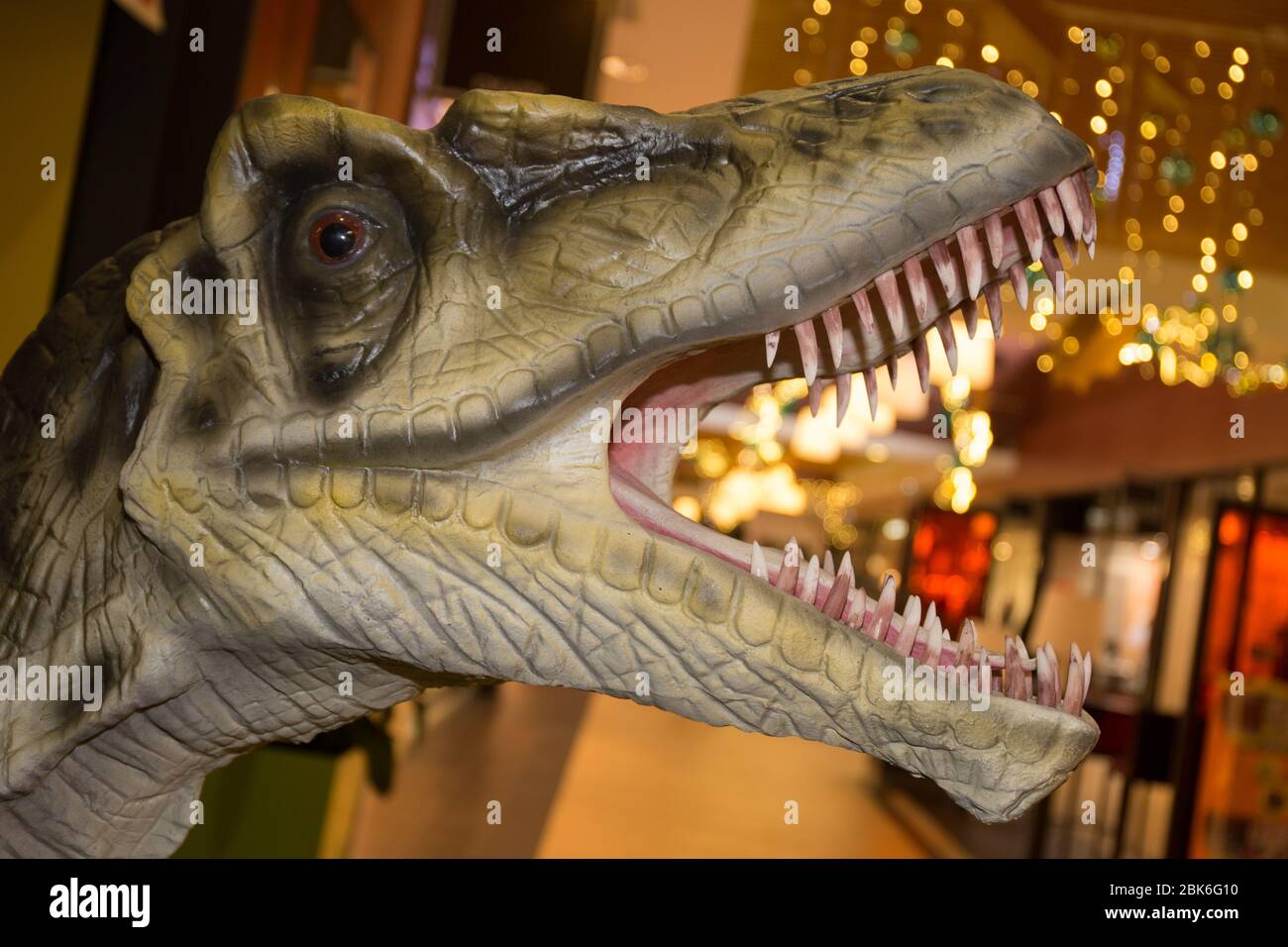 profile portrait of the head of a toy dinosaur with its multiple teeth ...