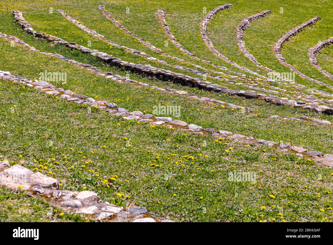 green grass and stone steps of outdoor amphitheater in sunny day ...