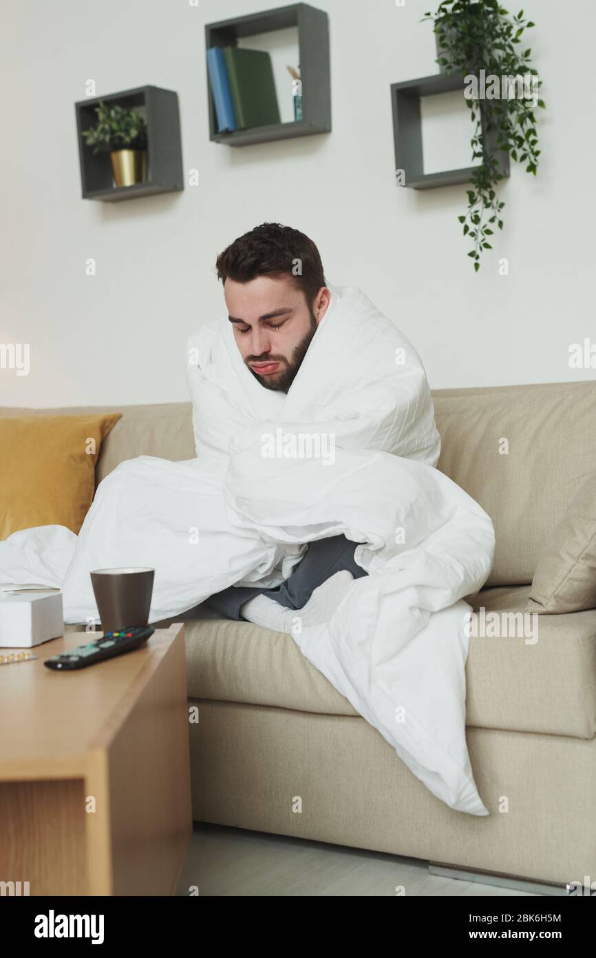 Sick male wrapped in blanket hi-res stock photography and images - Alamy