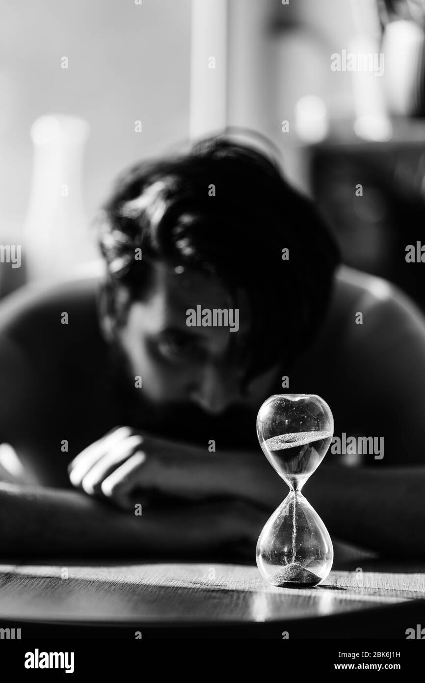 Man looking at hourglass, counting time in quarantine Stock Photo - Alamy