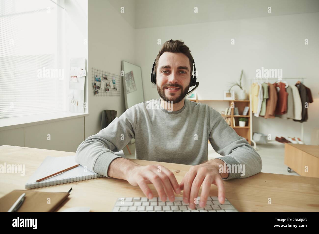 Friendly young bearded customer support representative pressing keypad ...