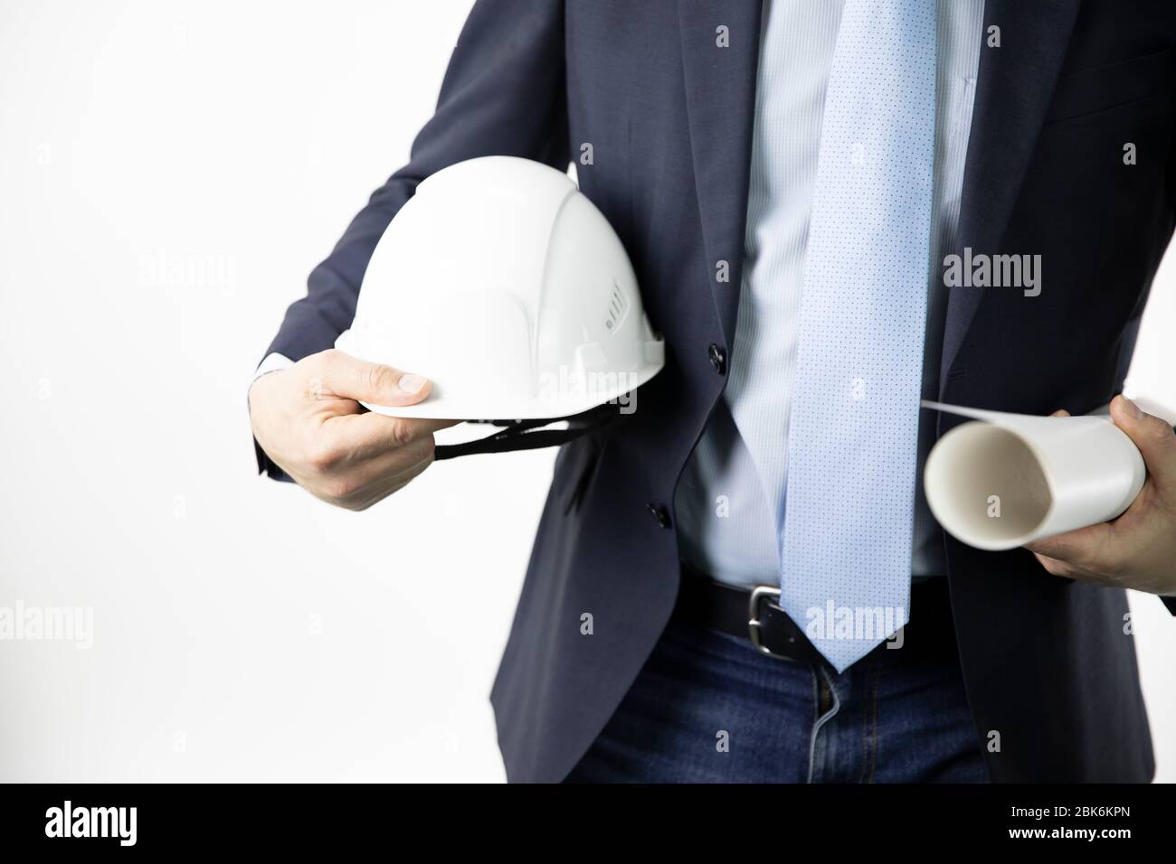 Close up engineer in formal suit holds hard safety helmet hat and ...