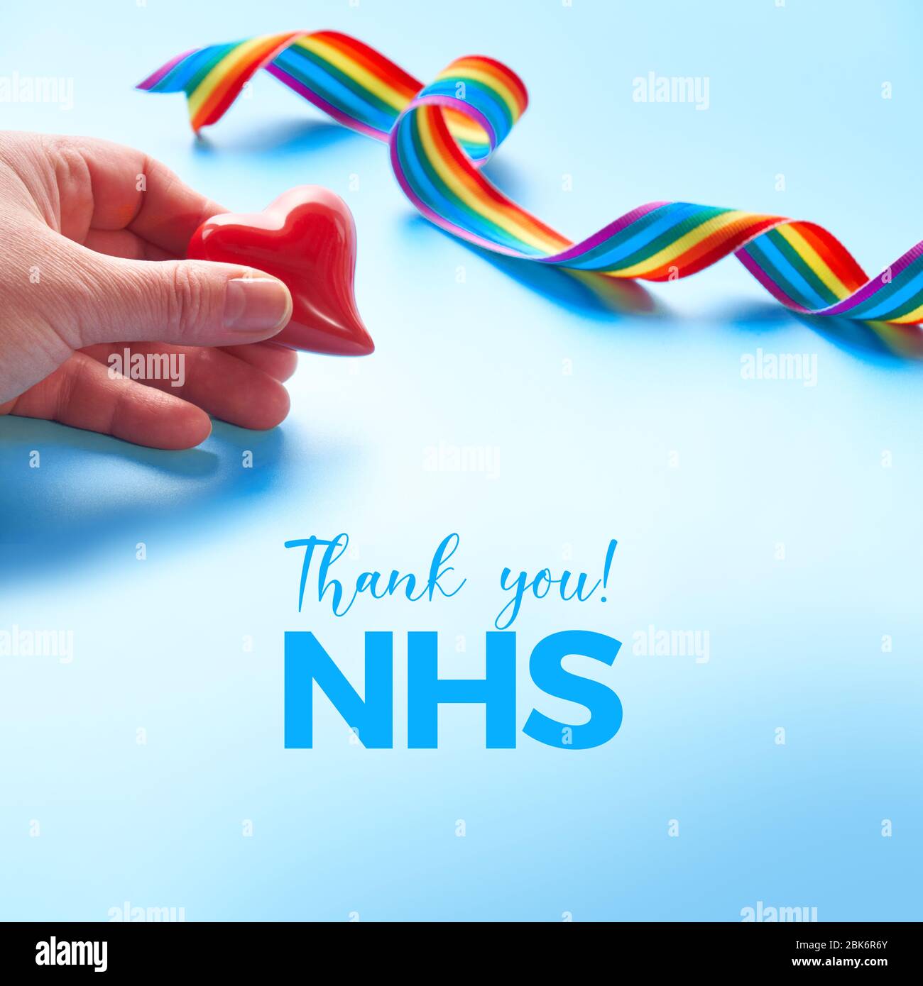Text "Thank you NHS" on blue. Rainbow ribbon and hand holding heart ...