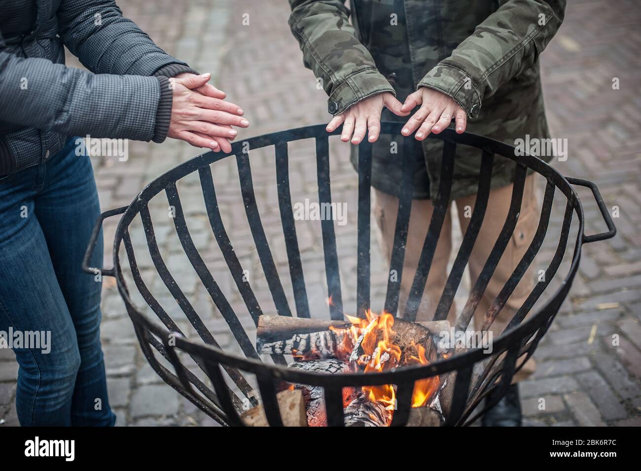 Close-up detail top view of woman warming his hands around hot fire ...