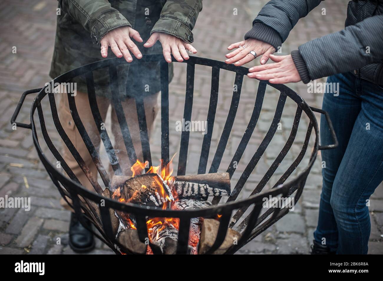 Close-up detail top view of woman warming his hands around hot fire ...