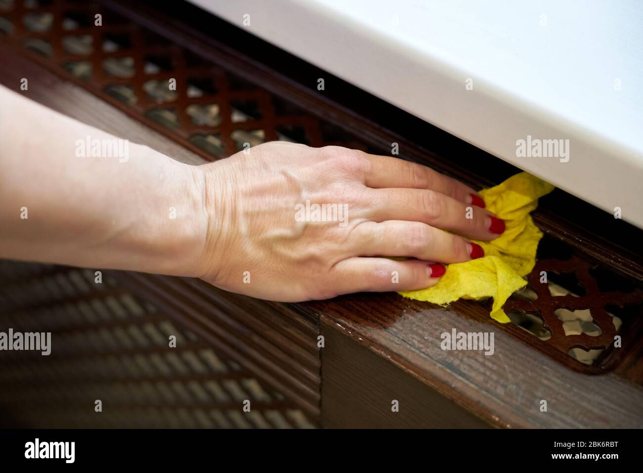 Woman wipes a window sill with a damp yellow rag Stock Photo - Alamy