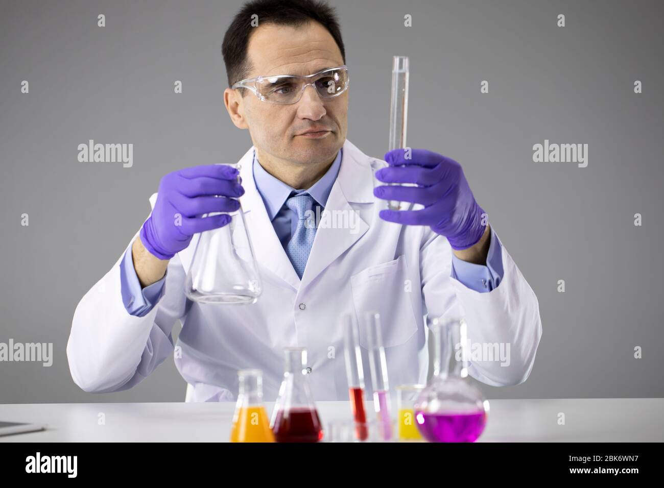 Smart scientist in protective goggles works at chemistry lab with ...