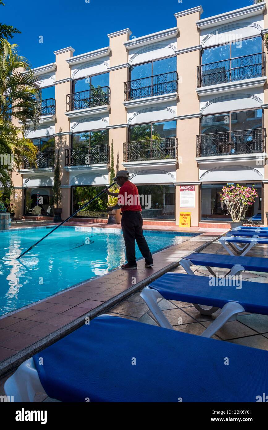 Man cleans the swimming pool in a deserted hotel in Merida due to ...