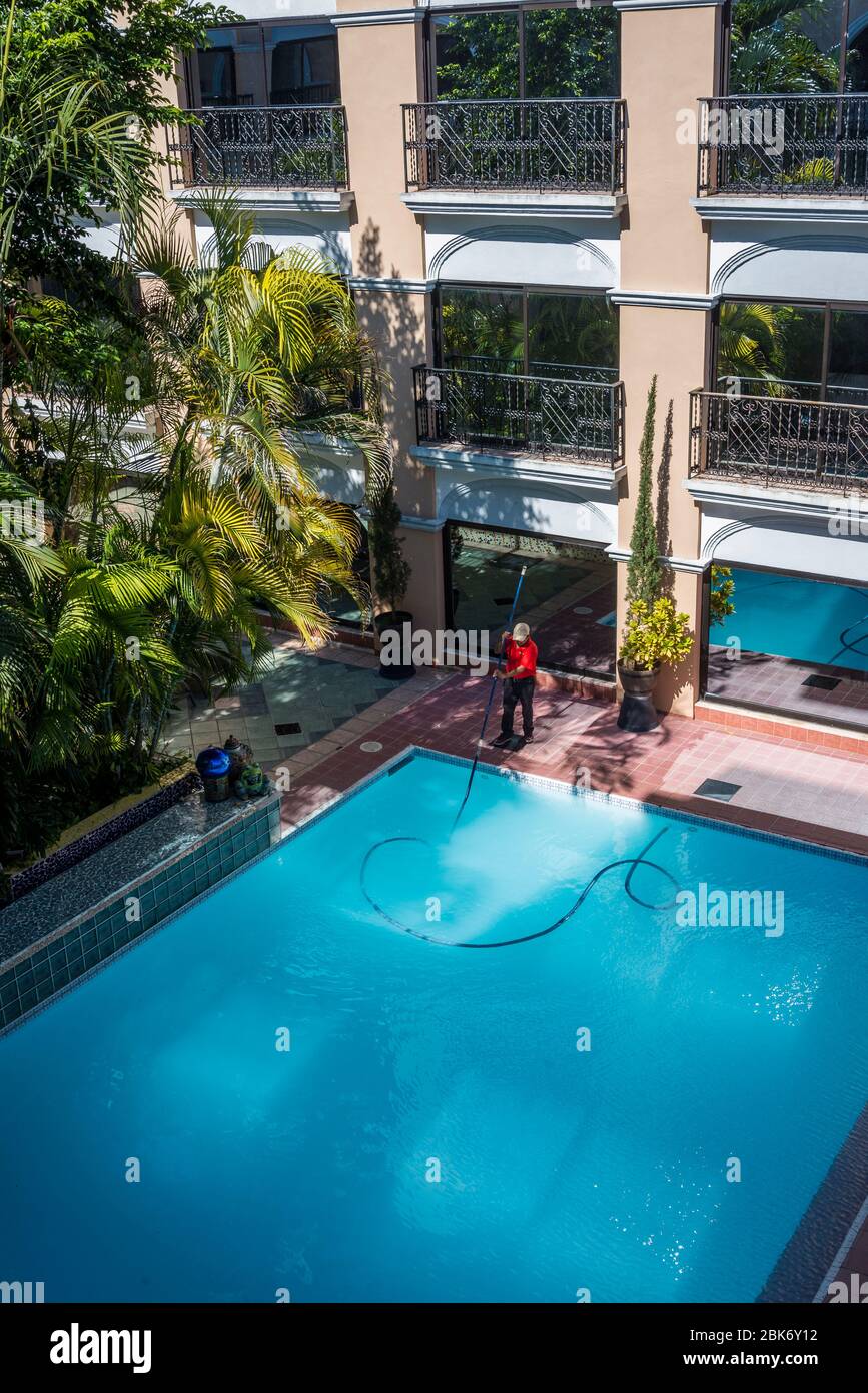 Man cleans the swimming pool in a deserted hotel in Merida due to ...