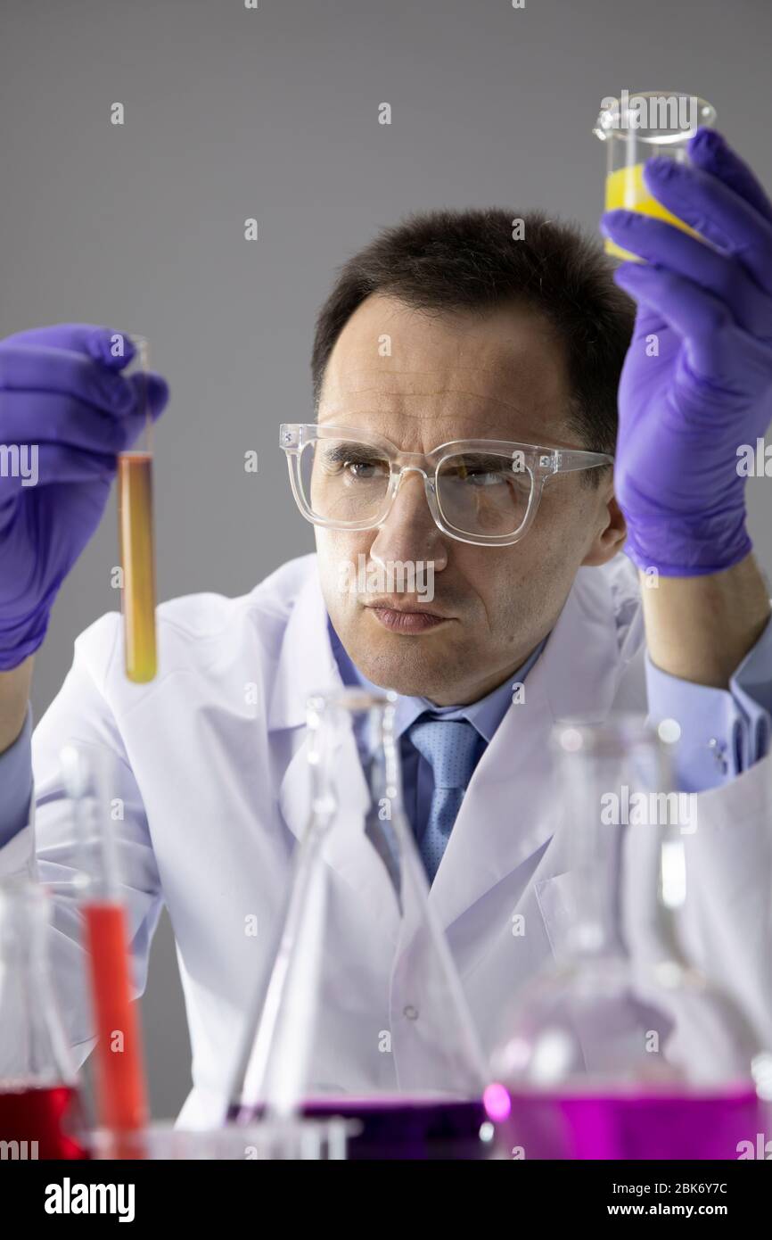 Scientist working at lab with test tubes flasks, performing science ...