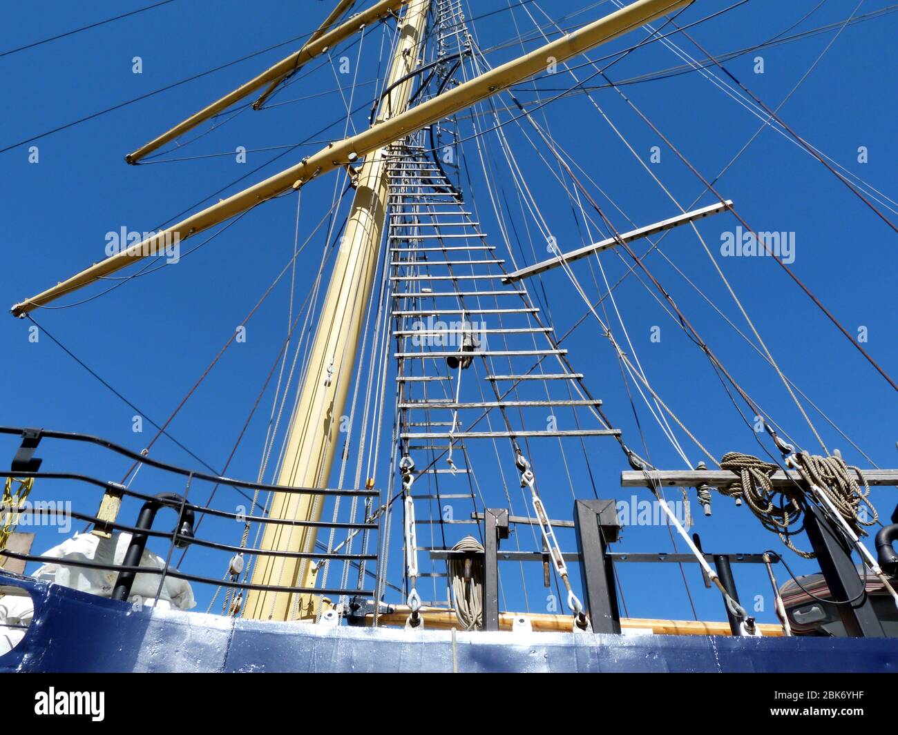 vintage sailboat detail with yellow stained wooden mast and cross beams ...