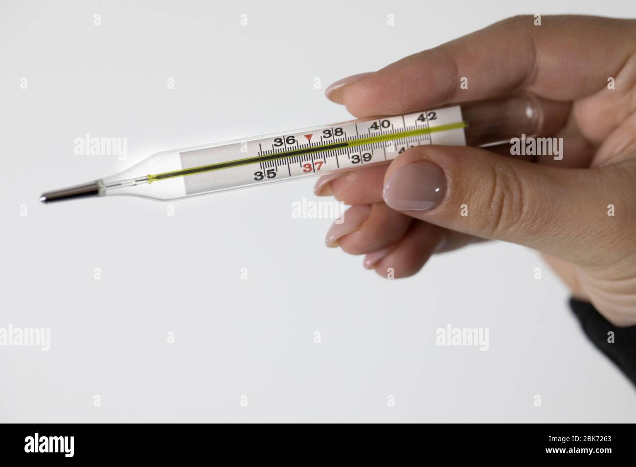 Close up medical thermometer in female hand which shows high body ...