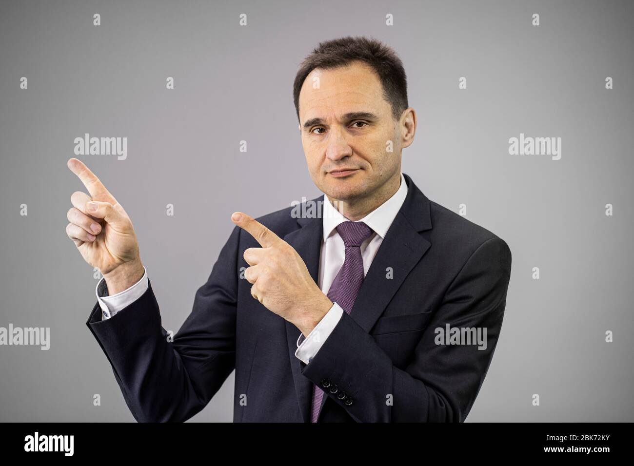 confident 40s businessman smiling pointing at copy space with his ...