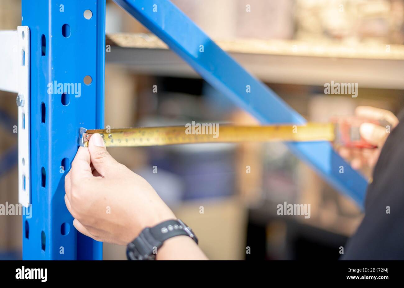 Male hand use the tape measure prepare to assembling the metal rack in ...