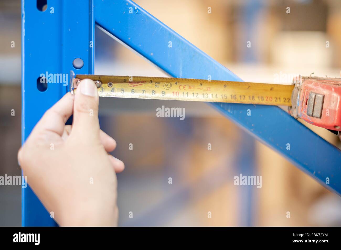 Male hand use the tape measure prepare to assembling the metal rack in ...